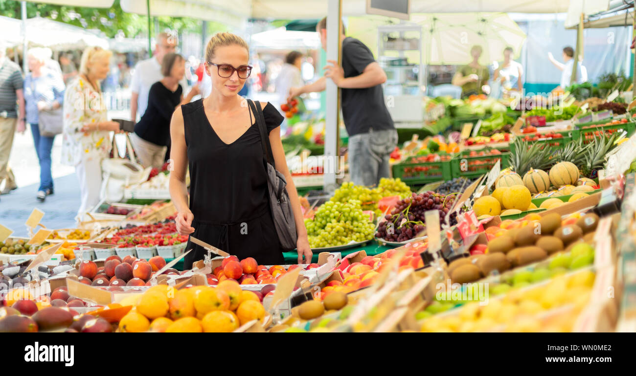 Woman buying fruits and vegetables at local food market. Market stall ...