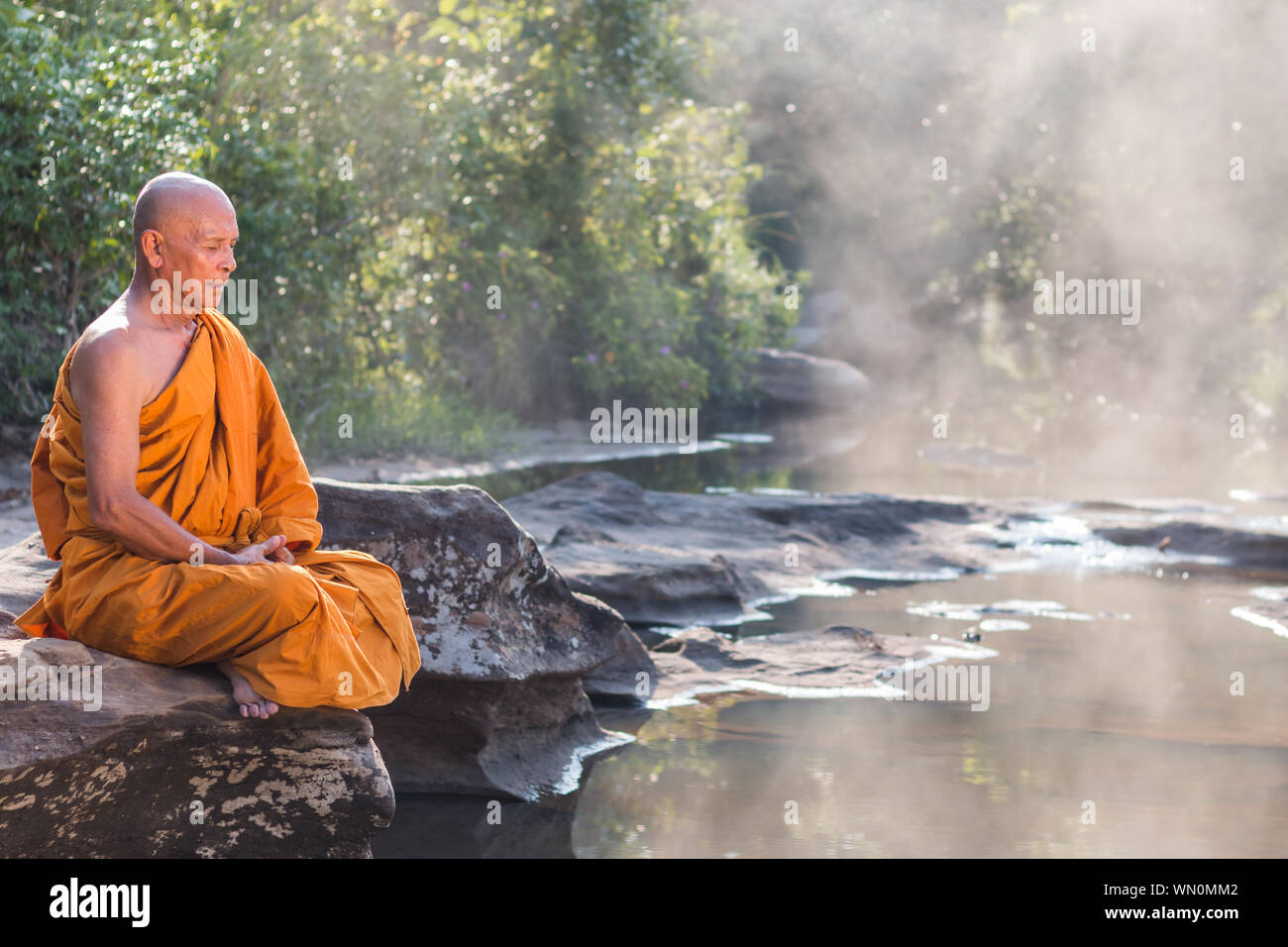 Senior Buddhist Monk By The Water Stock Photo - Alamy