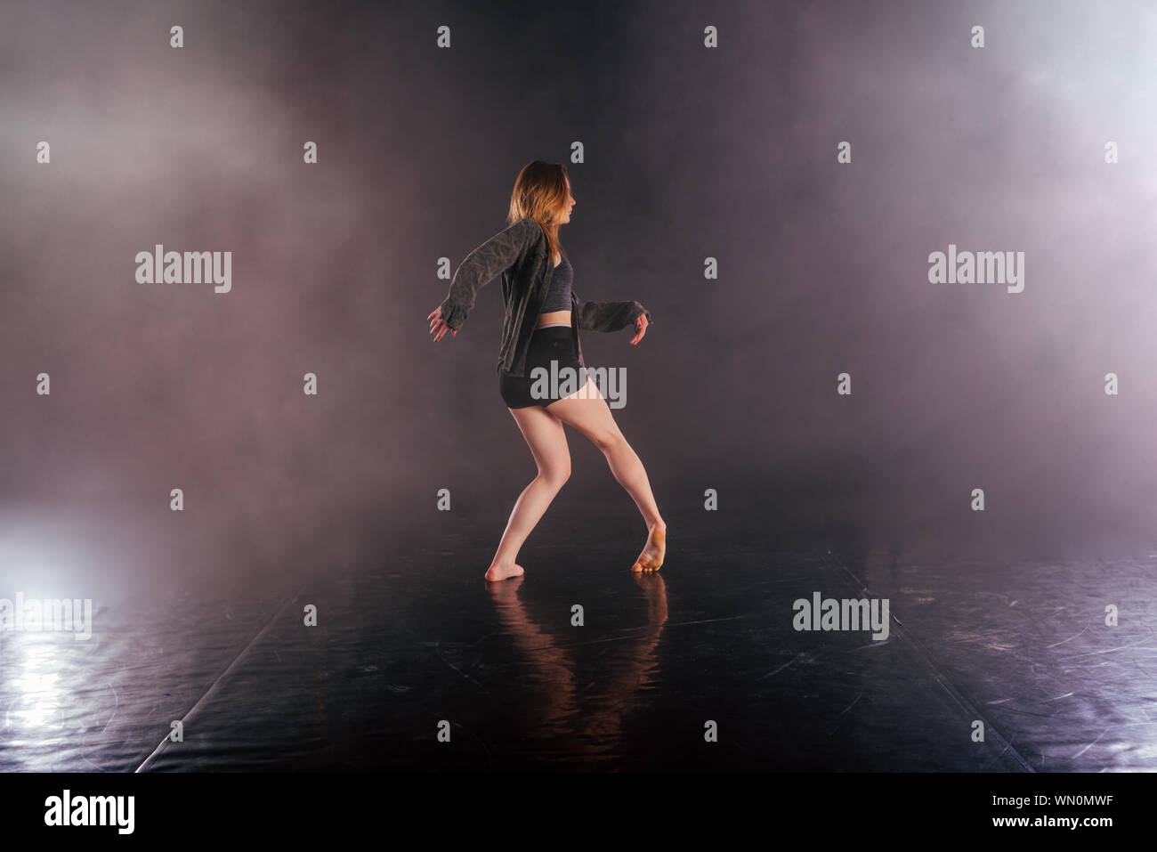 Shoeless female dance shows off her modern art dance moves while ...