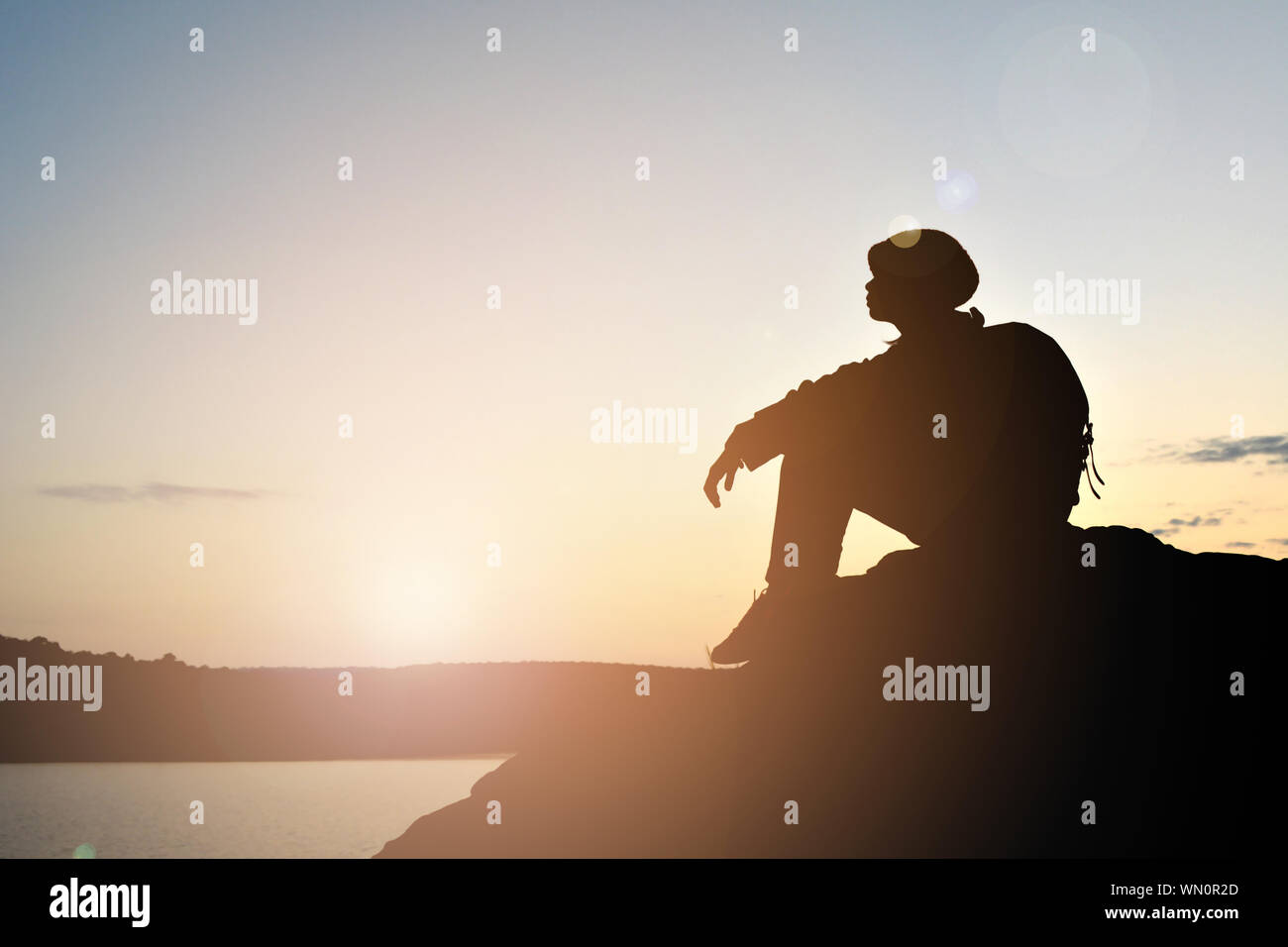 Silhouette man sitting sunset in hi-res stock photography and images ...