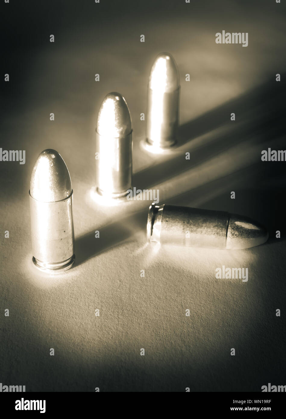 Three standing 9mm bullets alongside a fallen bullet with dramatic side ...