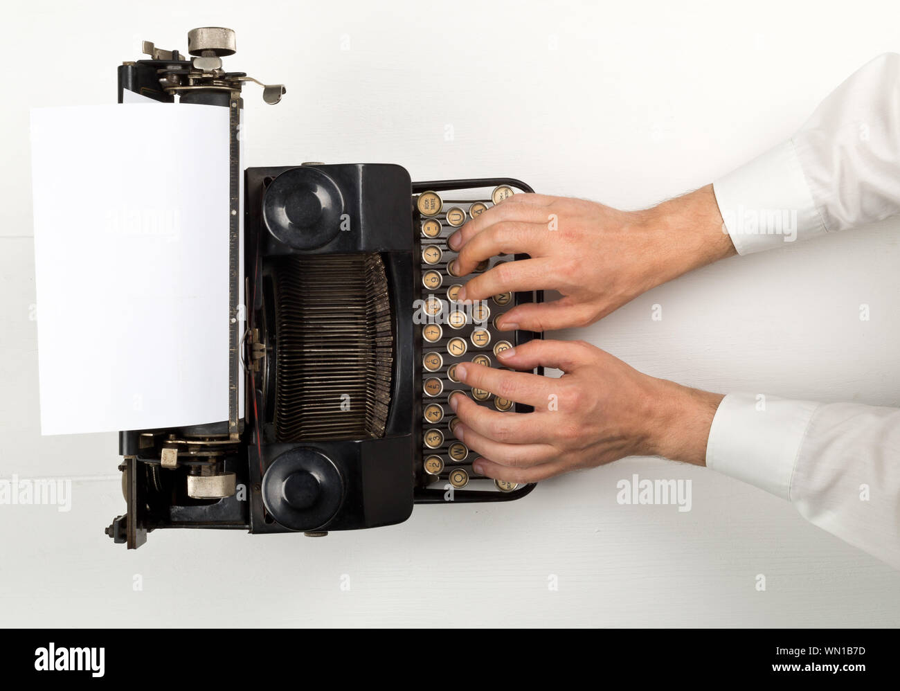 Man typing on vintage retro typewriter on white wooden table background ...