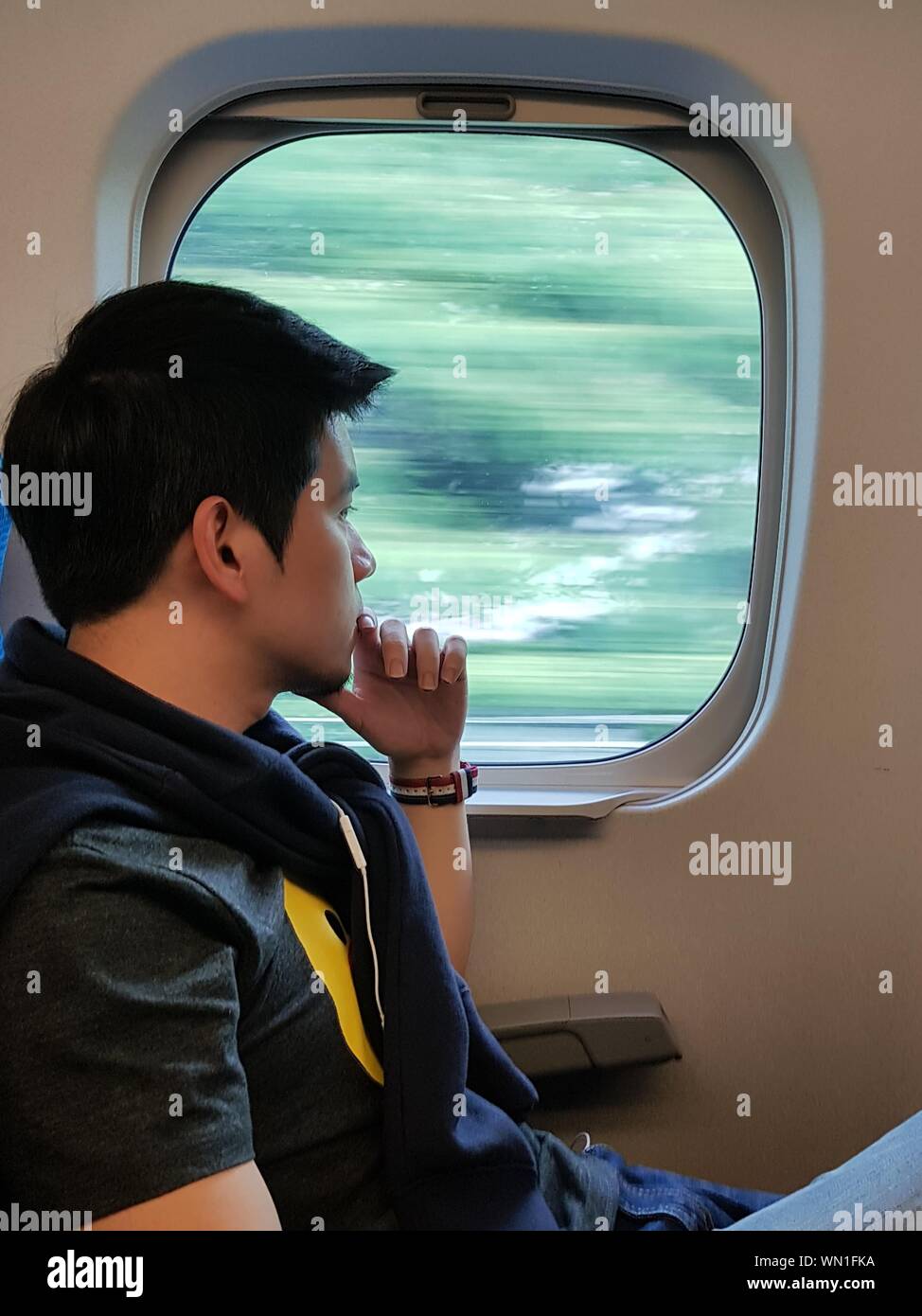 Side View Of Man Looking Through Train Window Stock Photo - Alamy