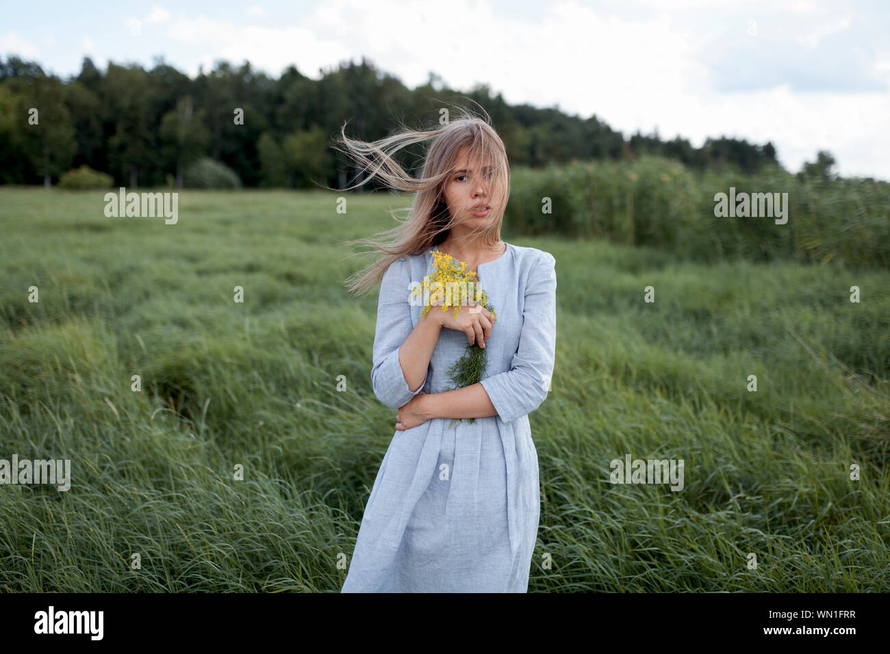 Windswept woman holding yellow hi-res stock photography and images - Alamy
