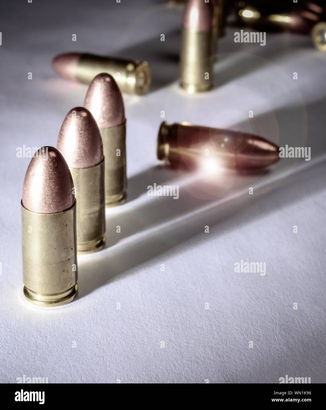 Three standing 9mm bullets alongside two fallen bullets with dramatic ...