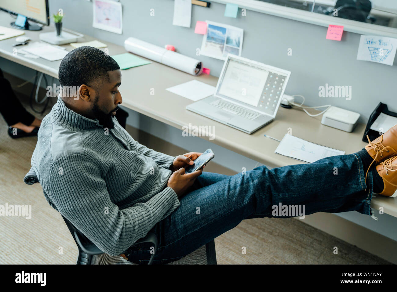 Using laptop with feet on desk hi-res stock photography and images - Alamy