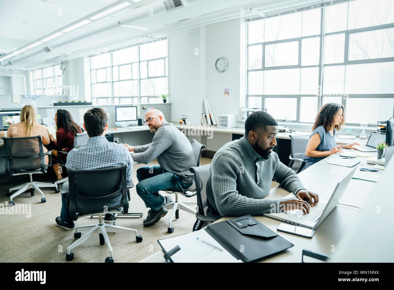 Workers using computers in office Stock Photo - Alamy