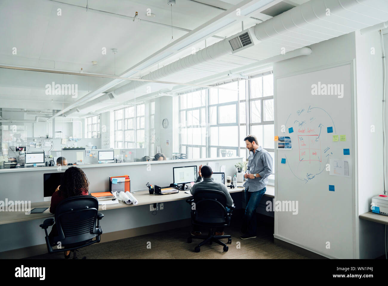 Workers using computers in office Stock Photo - Alamy