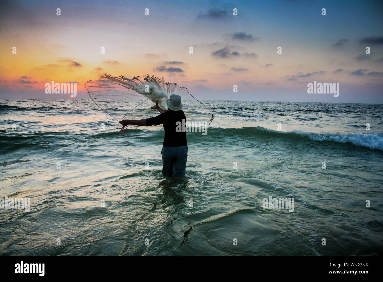Man Throwing Fishing Net Into Water High Resolution Stock Photography ...