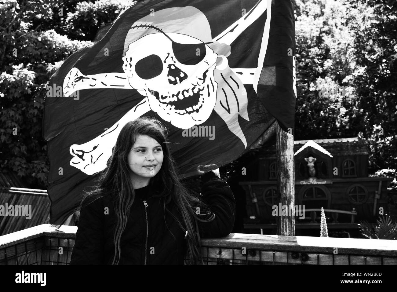 Girl Standing Against Pirate Flag Stock Photo - Alamy