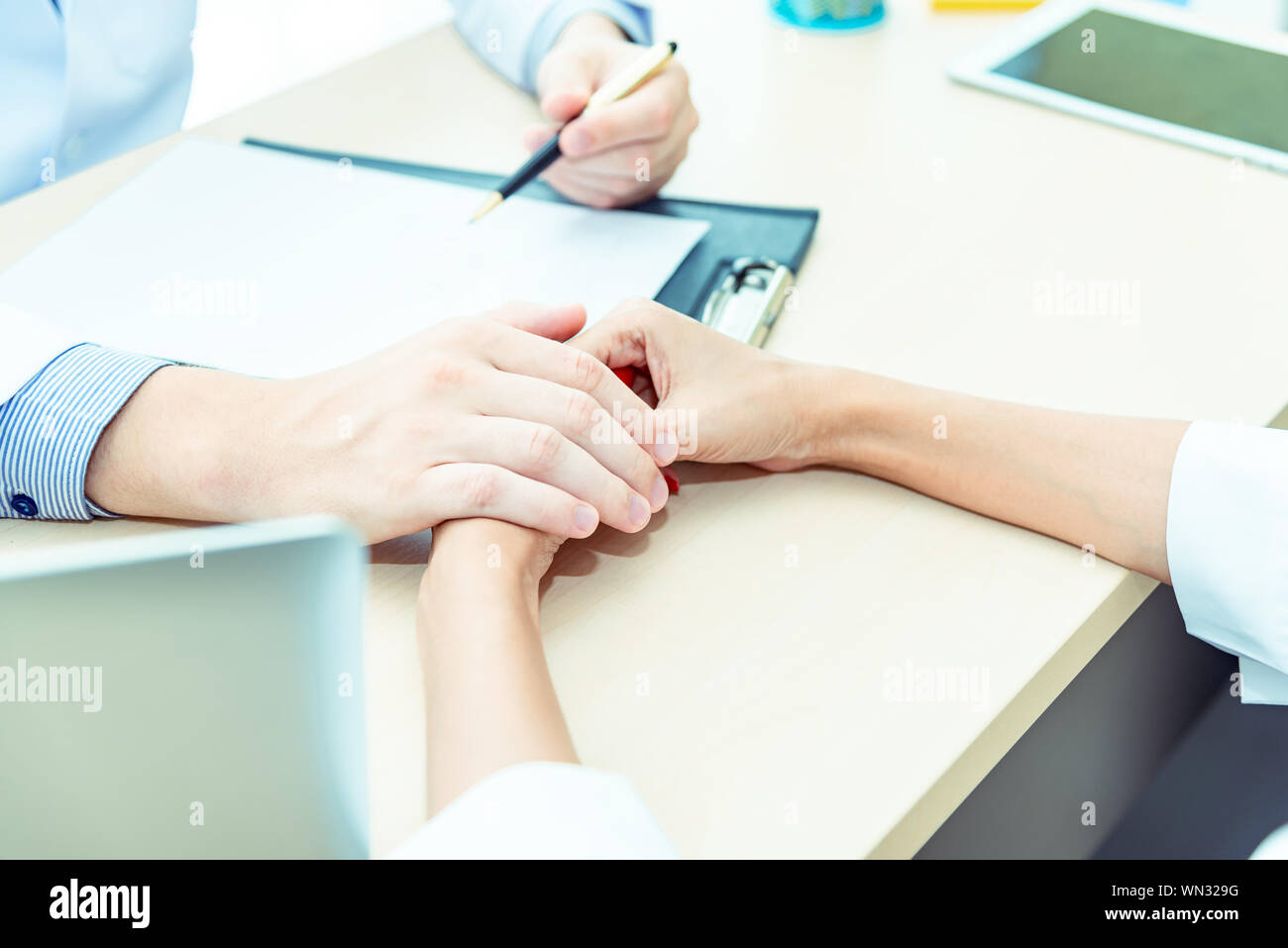 Professional doctor man with stethoscope reassuring woman patient on ...