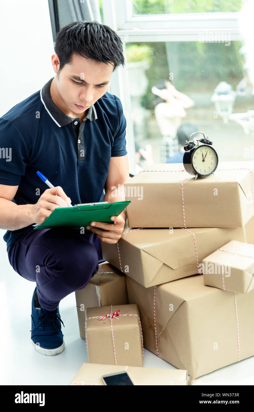 Asian man write document prepare to send products by order consumer ...