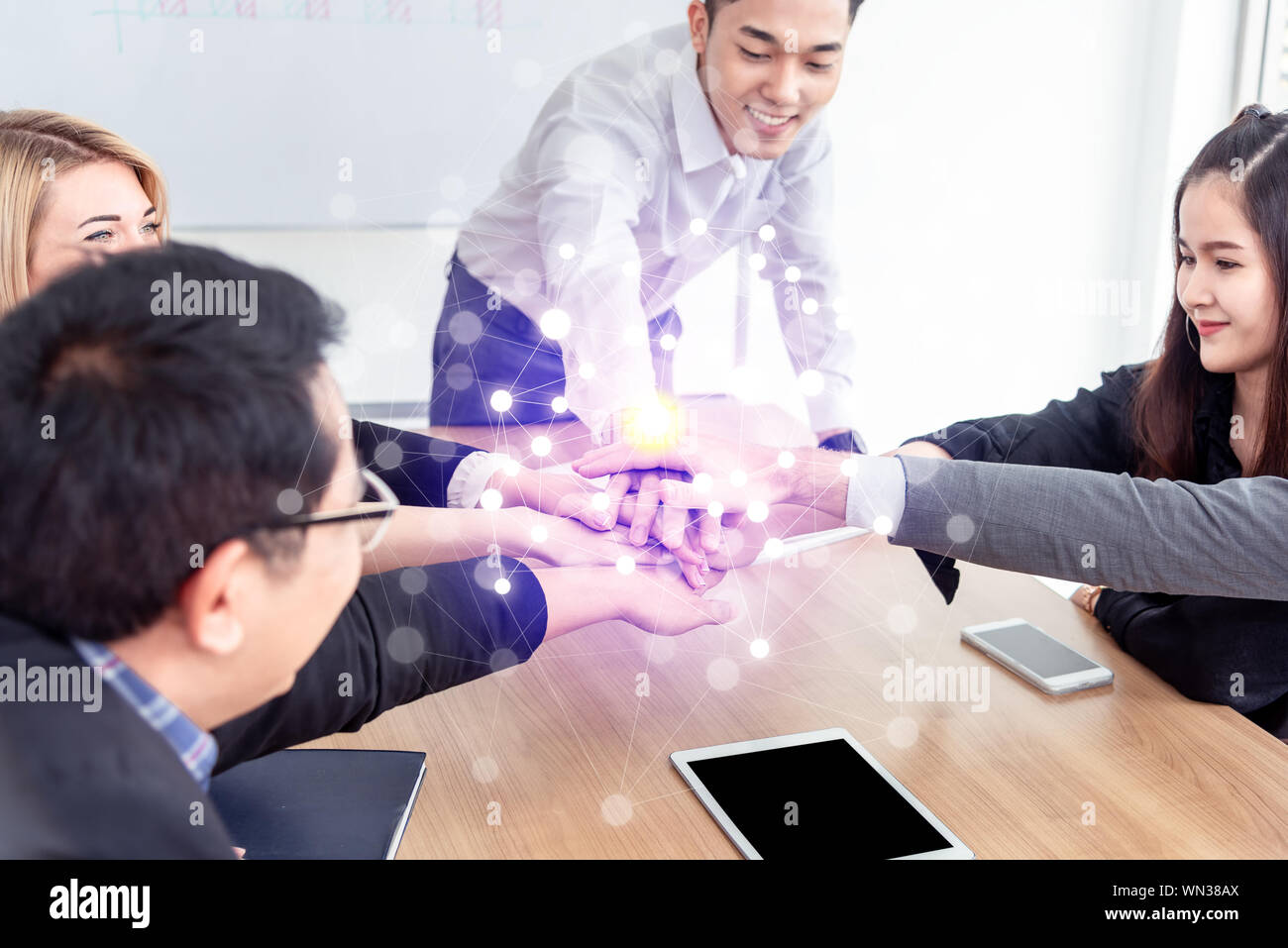 Multiracial business people collapse stacking hands over work table in ...