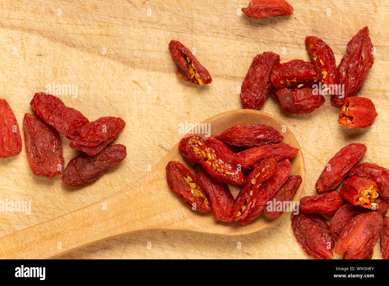 Close-up texture of dried red goji berries in a wooden scoop with ...
