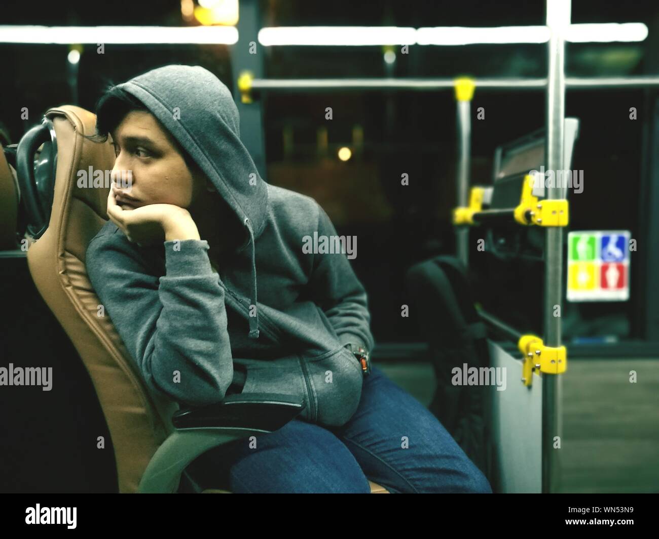 Bored Young Man With Hands In Pockets Sitting On Bus Seat Stock Photo ...