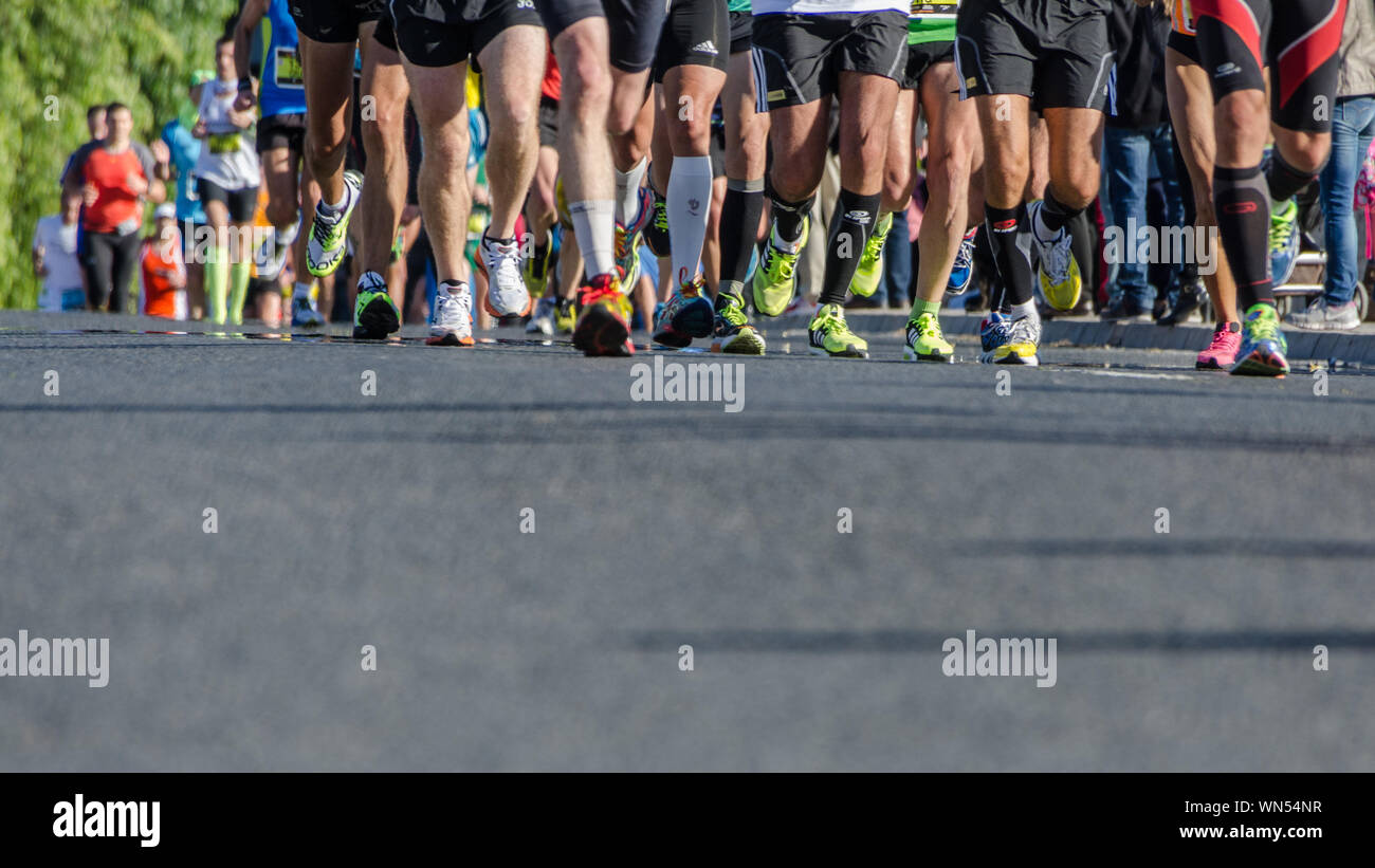 Asphalt with legs bottom of runners during the marathon of Valencia ...