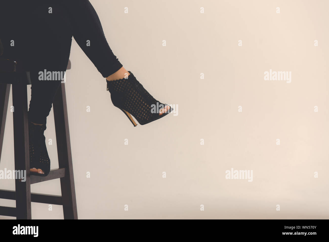 Woman sitting on stool legs crossed hi-res stock photography and images ...