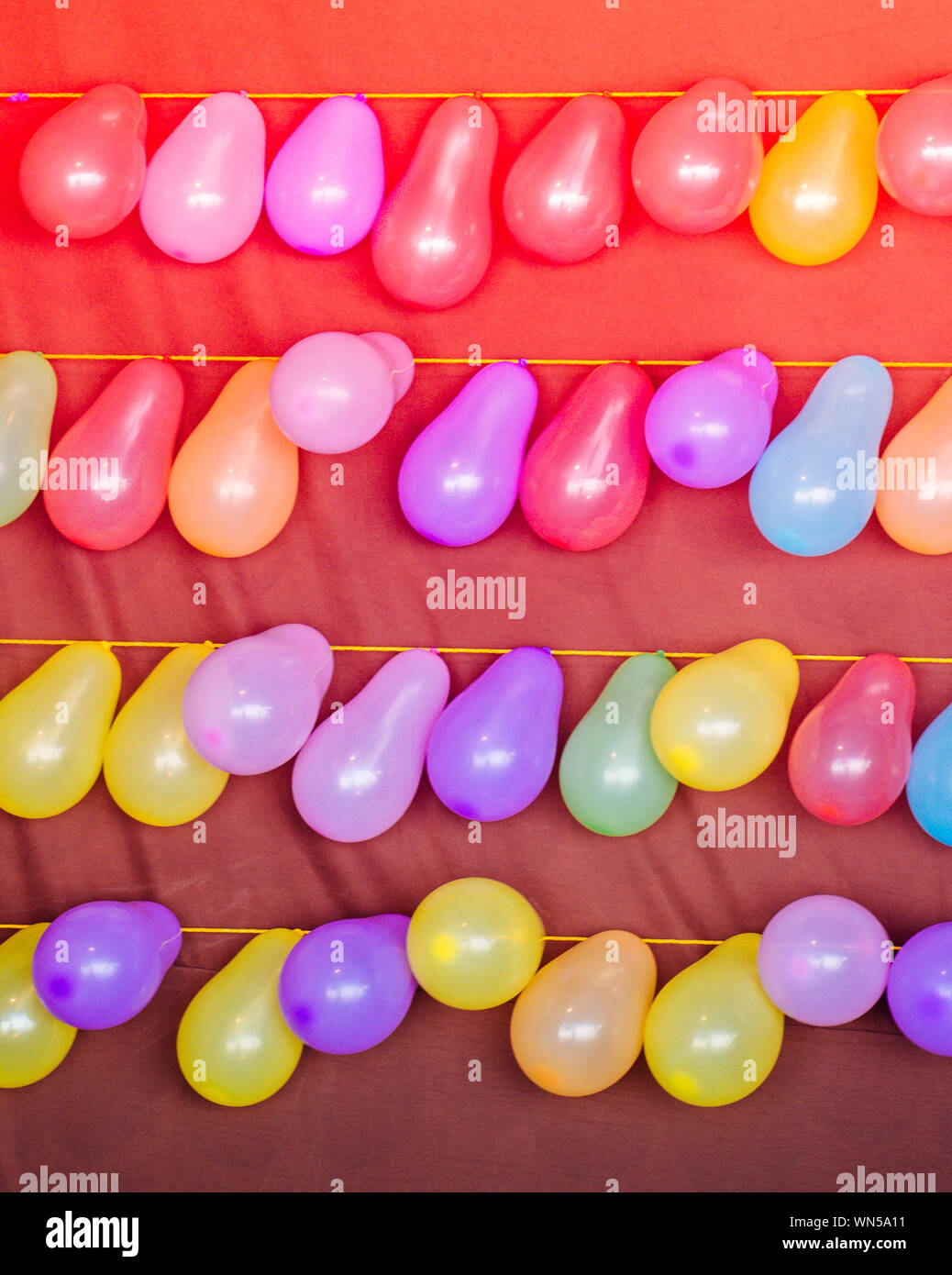 Balloon shooting game with balloons tied on a string Stock Photo - Alamy