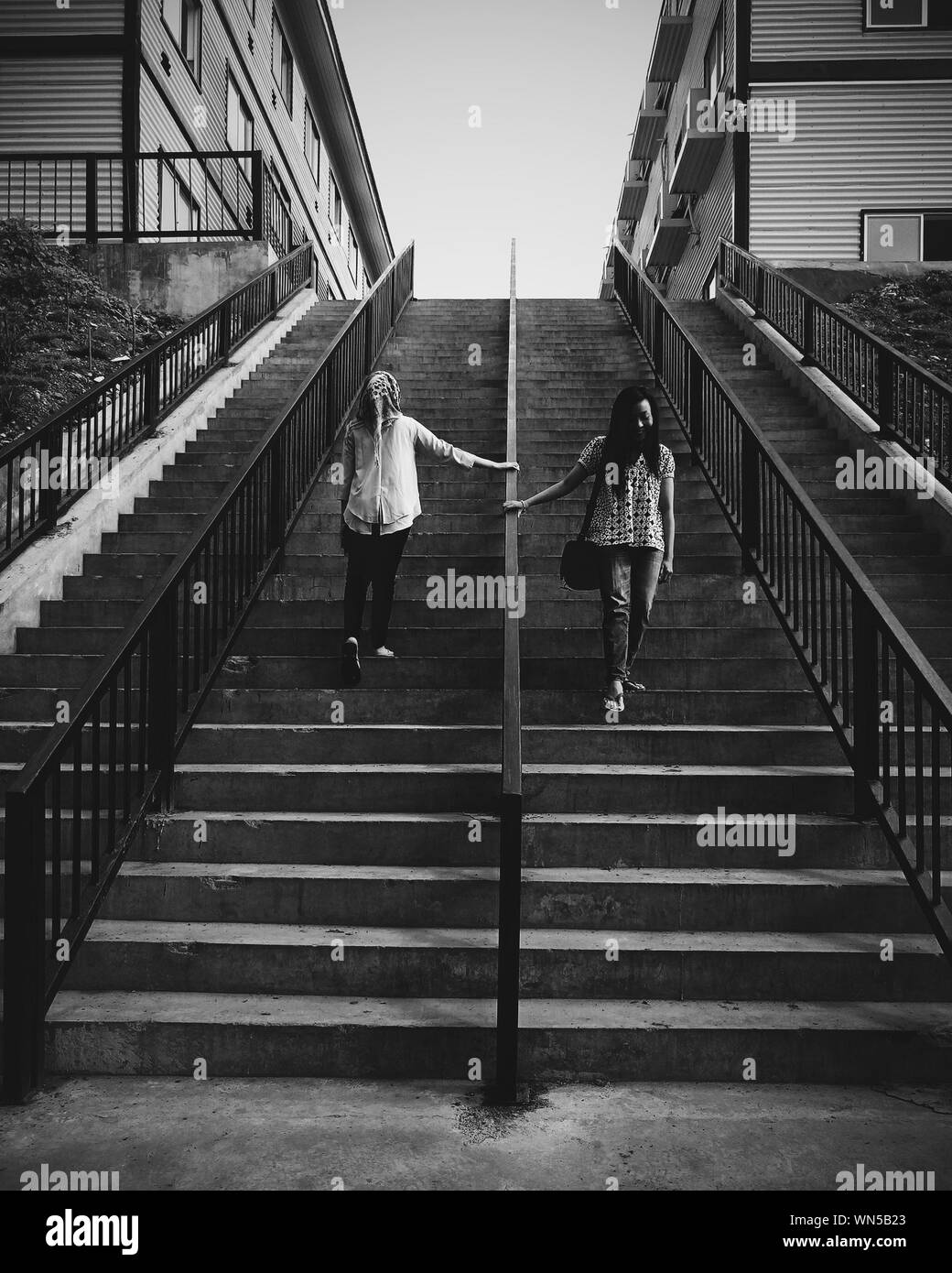 Two people walking down steps Black and White Stock Photos & Images - Alamy
