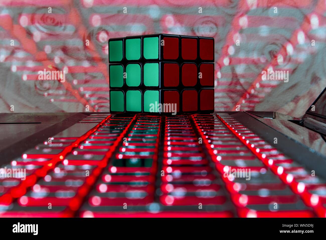 Rubik's cube isolated on a lightful laptop keyboard with a background ...