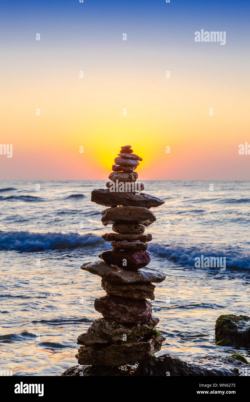 Zen Balancing Pebbles. Stack of pebbles on beach with sunrise on ...