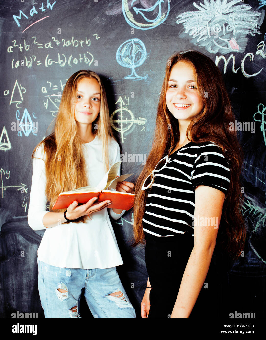 back to school after summer vacations, two teen girls in classroom with ...