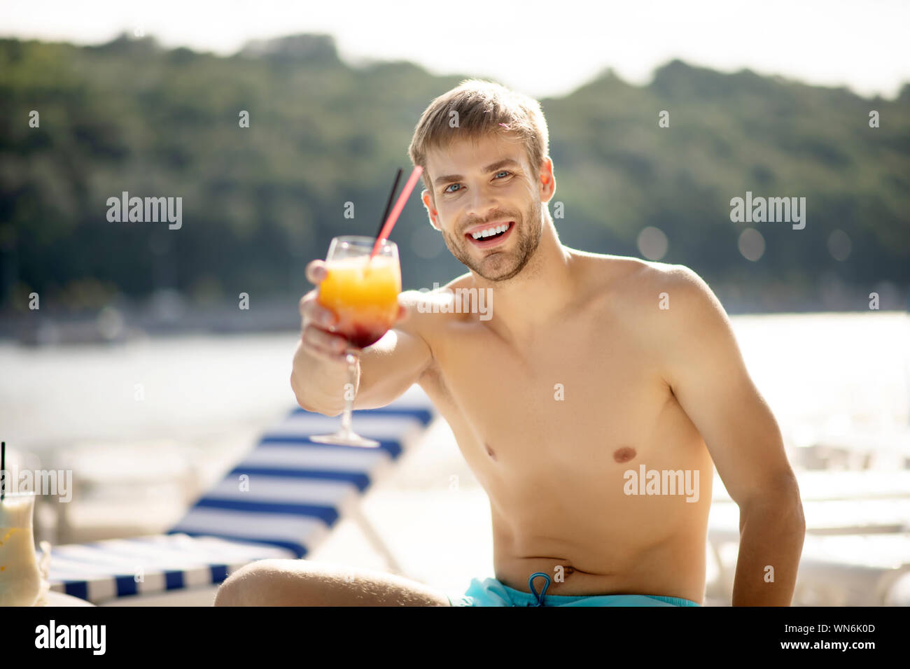 Man drinking cocktail while chilling and sunbathing Stock Photo - Alamy
