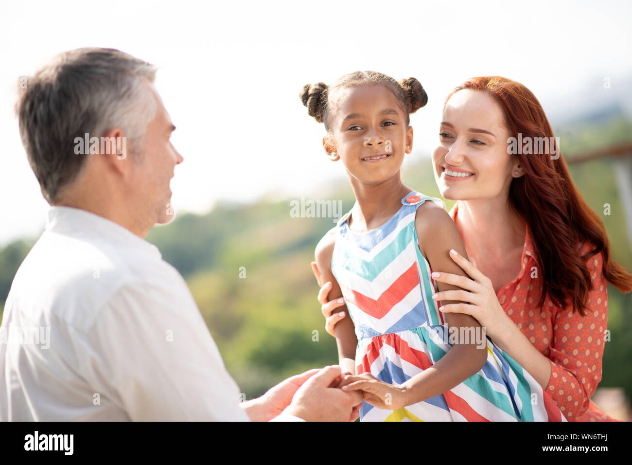 Beautiful red-haired woman hugging her foster daughter Stock Photo - Alamy