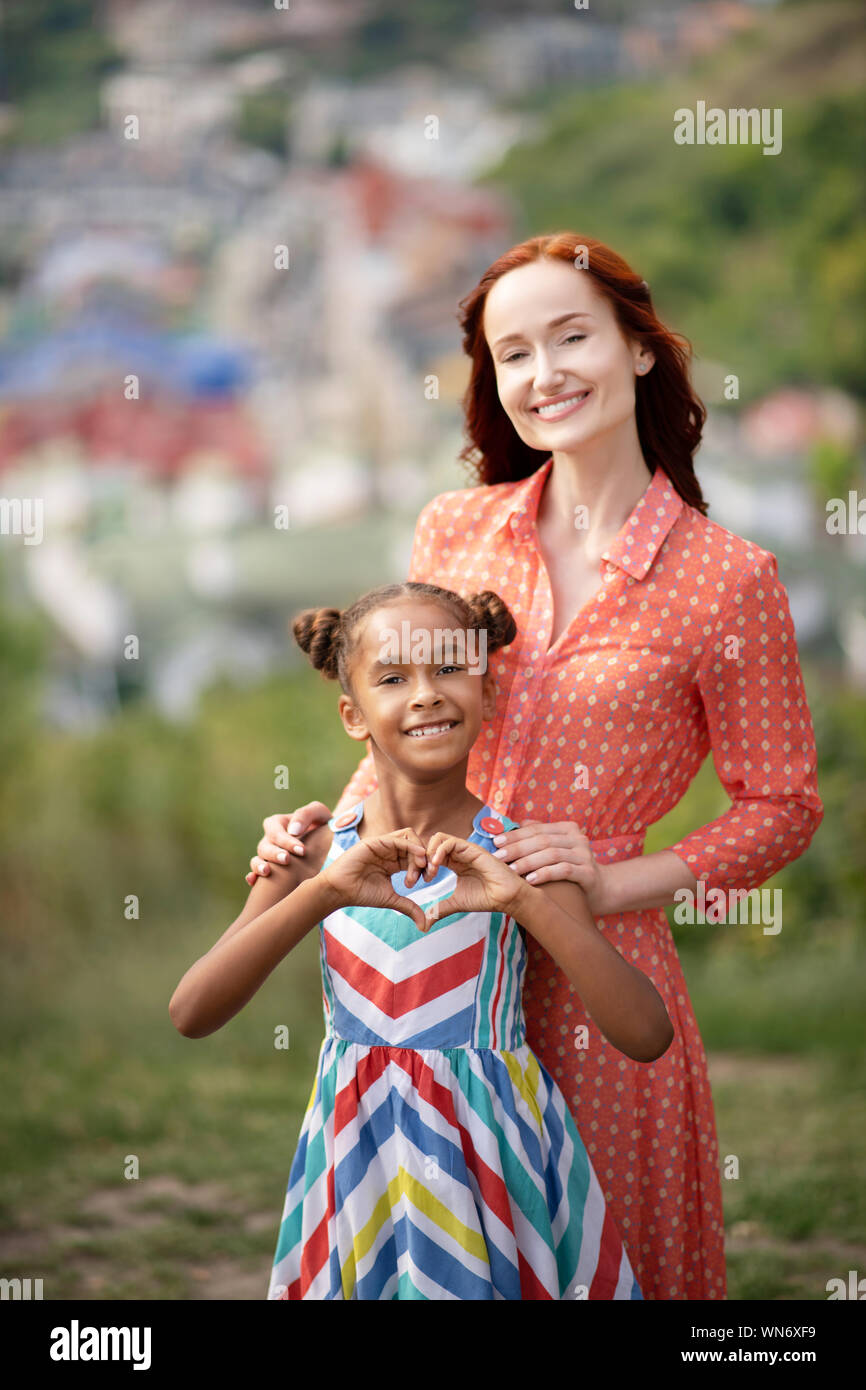 Woman smiling while standing with her adopted daughter Stock Photo - Alamy