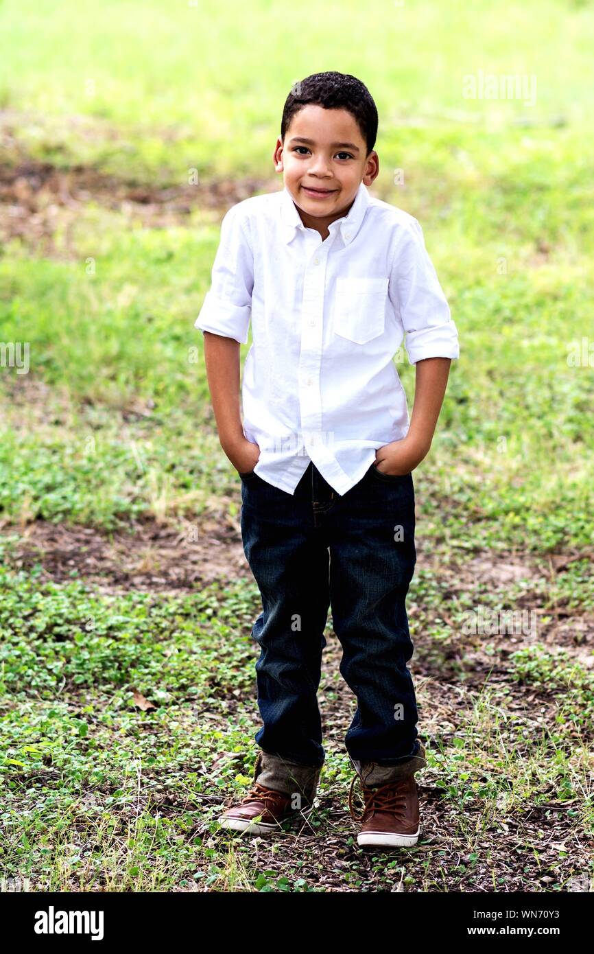 Smiling childhood standing hands in pockets hi-res stock photography ...