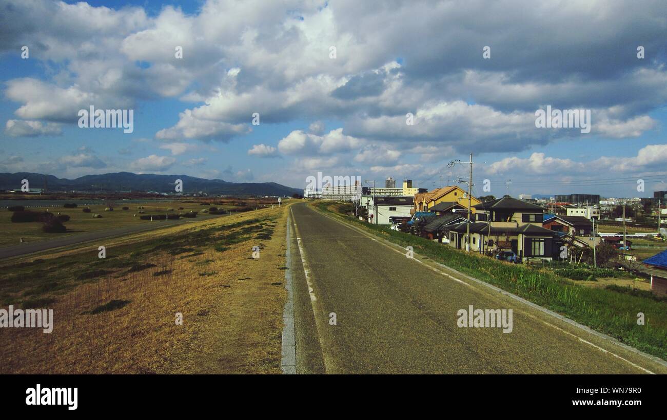 View Of Empty Road Along Houses Stock Photo - Alamy
