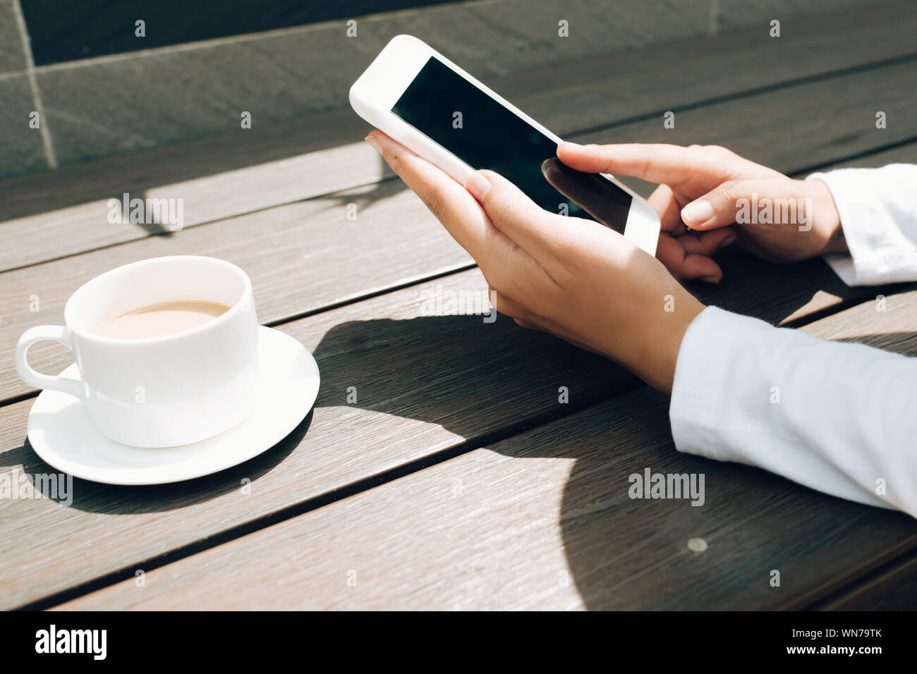 Woman hand texting for someone with black screen at coffee shop Stock ...