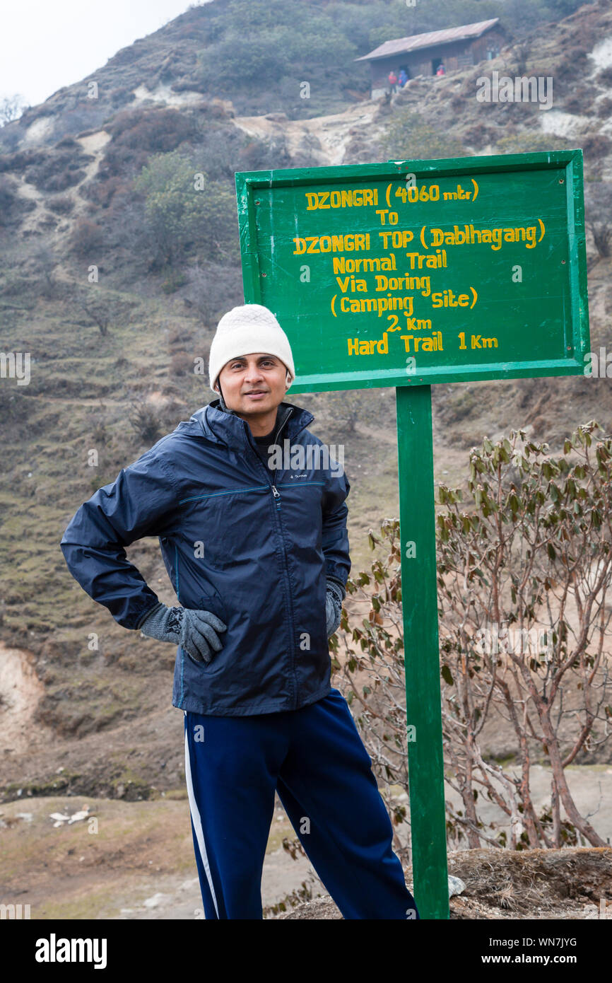 A man stands next to a sign post on the Gochela trek in the ...
