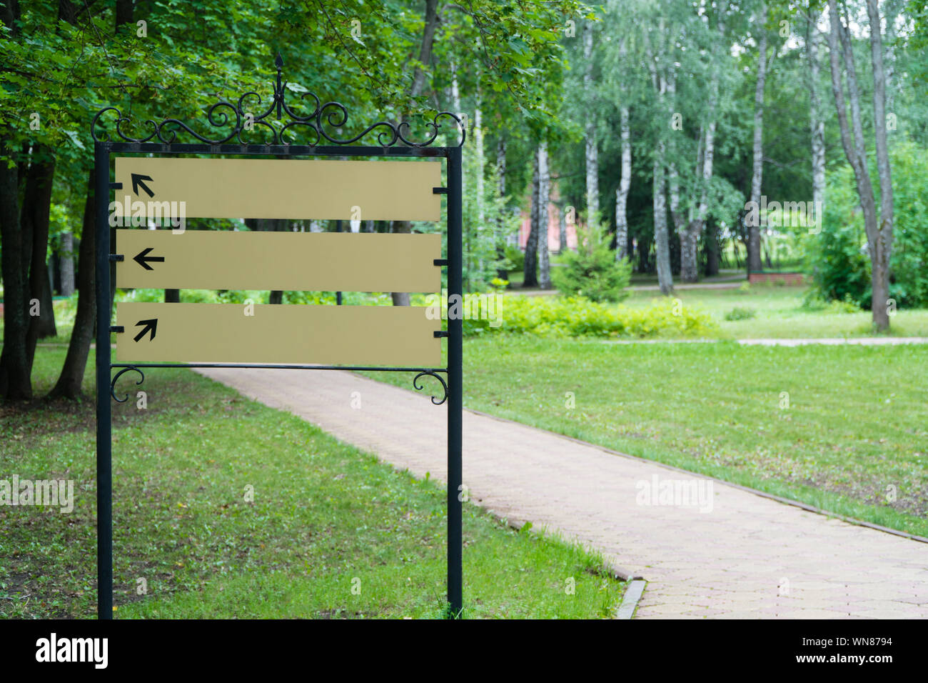 blank sign in the park by the path on the background of trees Stock ...