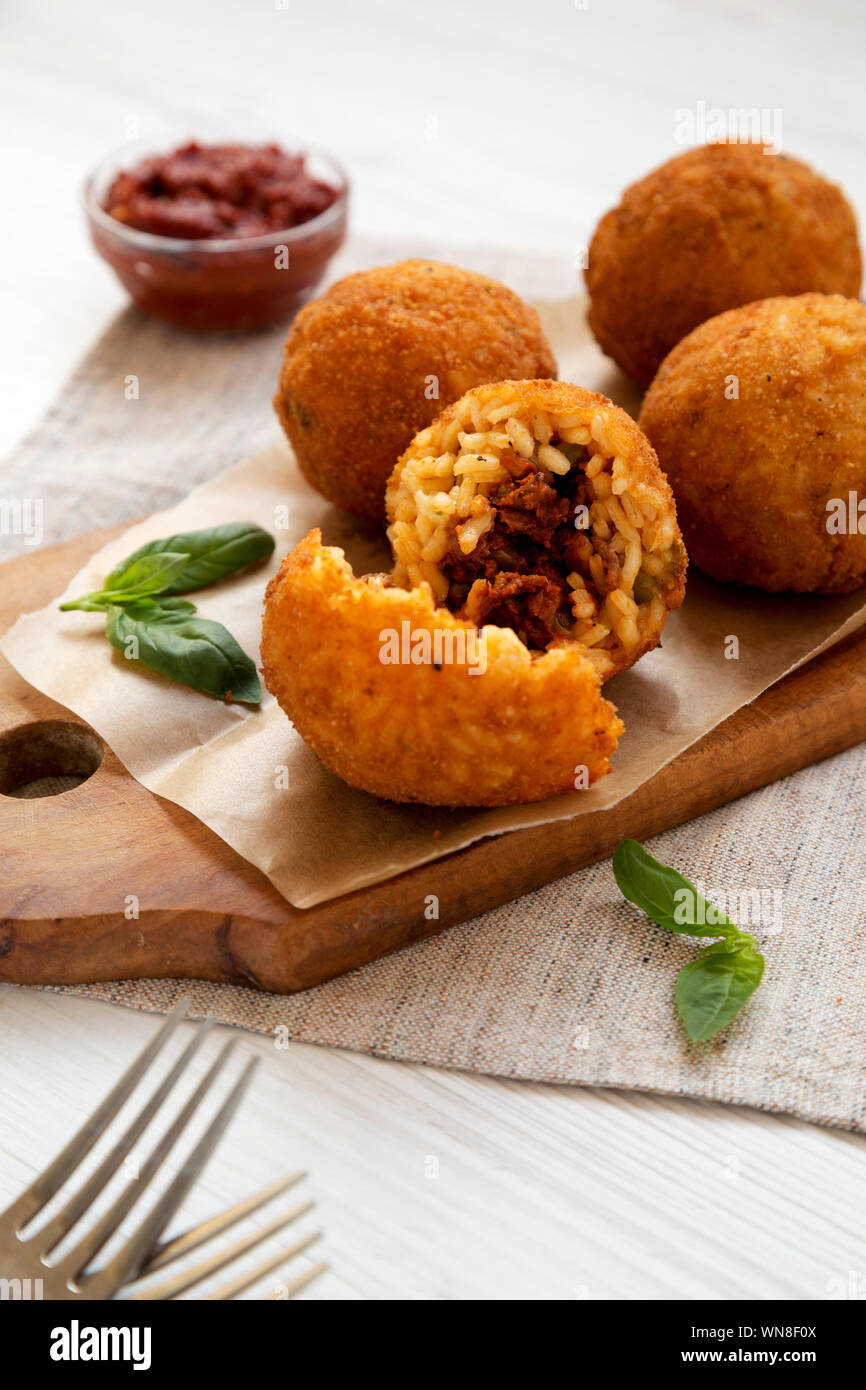 Homemade fried Arancini with basil and Marinara on a white wooden ...