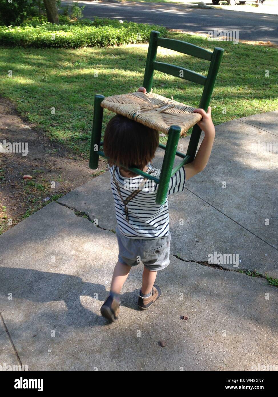 Boy by chair hi-res stock photography and images - Alamy