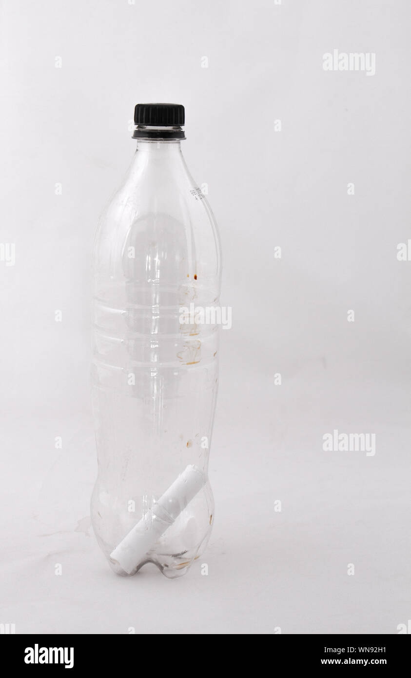 A bottle with a rolled up note inside isolated against a white ...