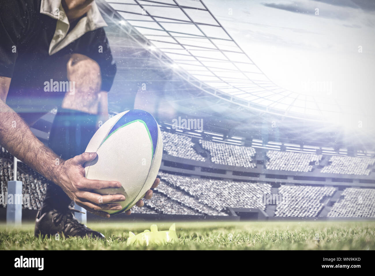 Composite image of male rugby player placing rugby ball on a stand in ...