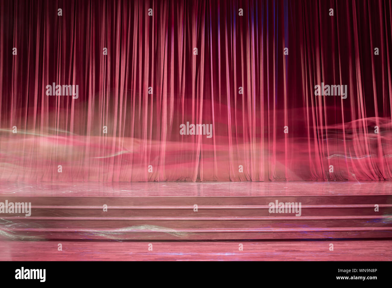 Old red curtains on stage with the movement of the actors in the ...