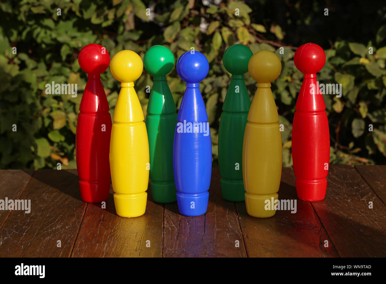 Colorful plastic toy bowling pins on wooden floor close up Stock Photo ...