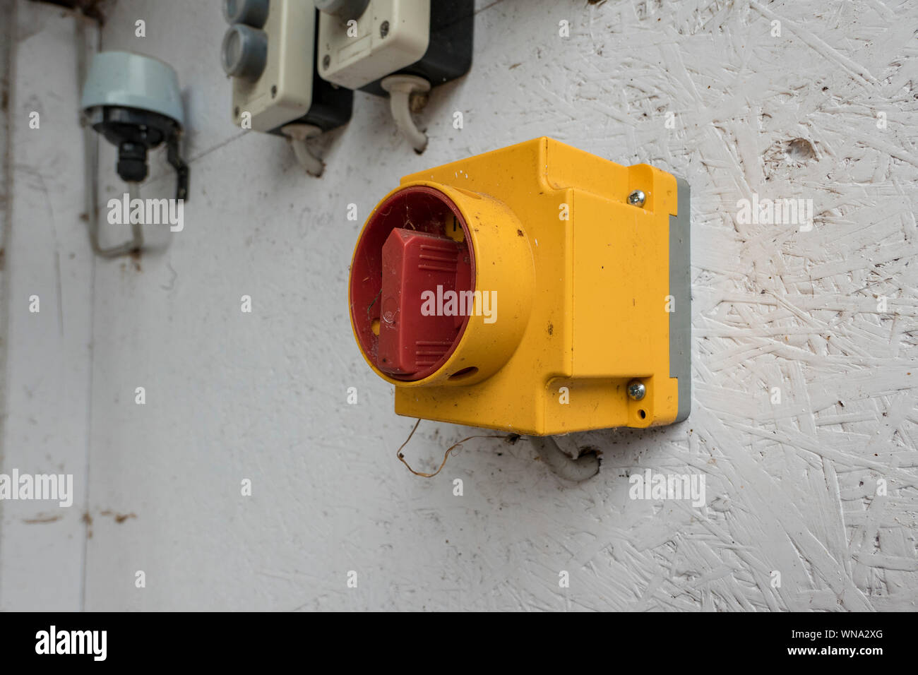 red yellow emergency stop switch on the wall of a house Stock Photo - Alamy
