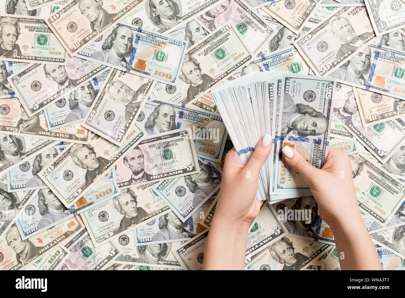 Top view of female hands counting money on dollar background. Debt ...