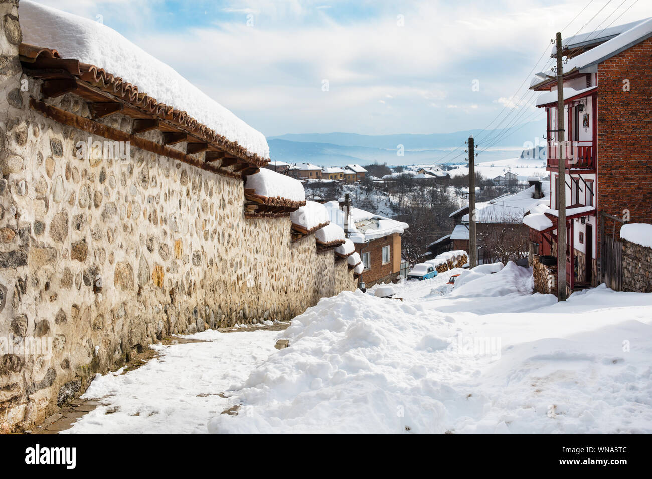 winter snow in traditional bulgarian balkan village with stone wall and ...