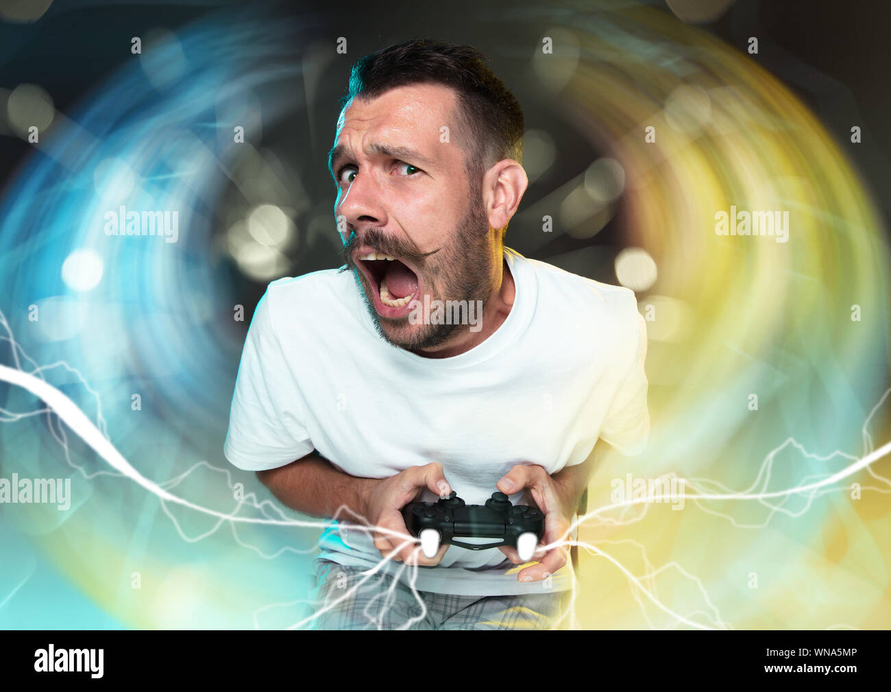 Enthusiastic gamer. Joyful young man holding a video game controller ...