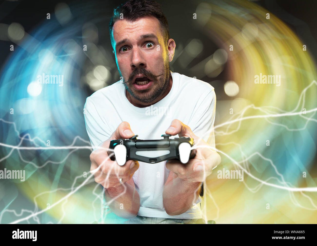 Enthusiastic gamer. Joyful young man holding a video game controller ...