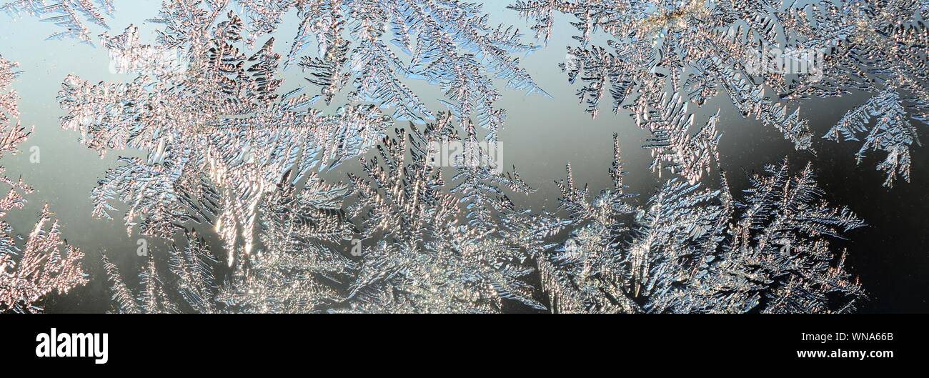 Snowflakes frost rime macro on window glass pane. Colorful ice on the ...