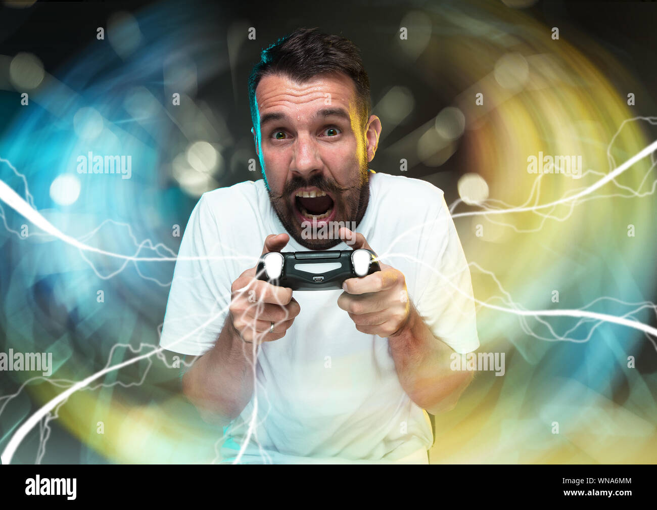 Enthusiastic gamer. Joyful young man holding a video game controller ...