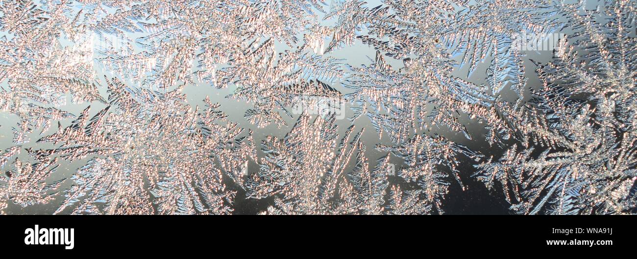 Snowflakes frost rime macro on window glass pane. Colorful ice on the ...