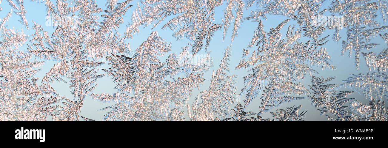 Snowflakes frost rime macro on window glass pane. Colorful ice on the ...