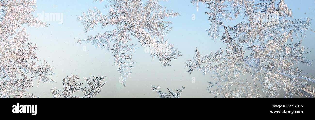 Snowflakes frost rime macro on window glass pane. Colorful ice on the ...
